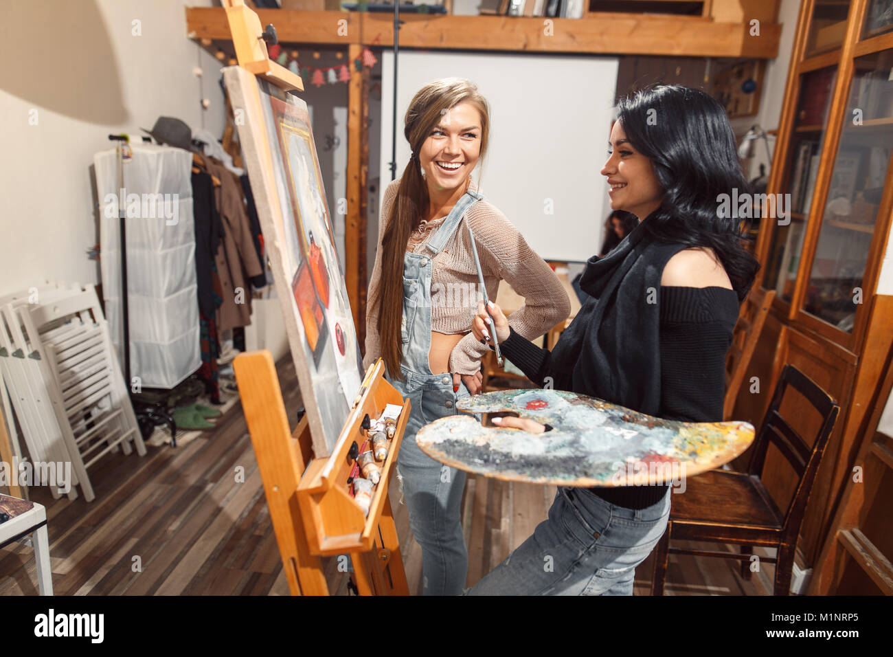 two girls in an artist studio. paints model Stock Photo - Alamy