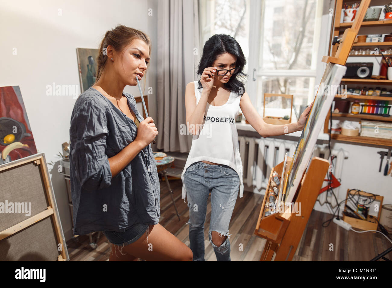 two girls in an artist studio. paints model Stock Photo - Alamy