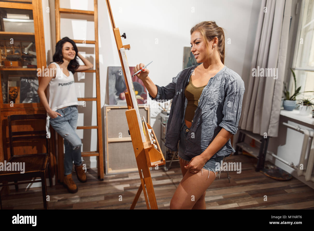 two girls in an artist studio. paints model Stock Photo - Alamy