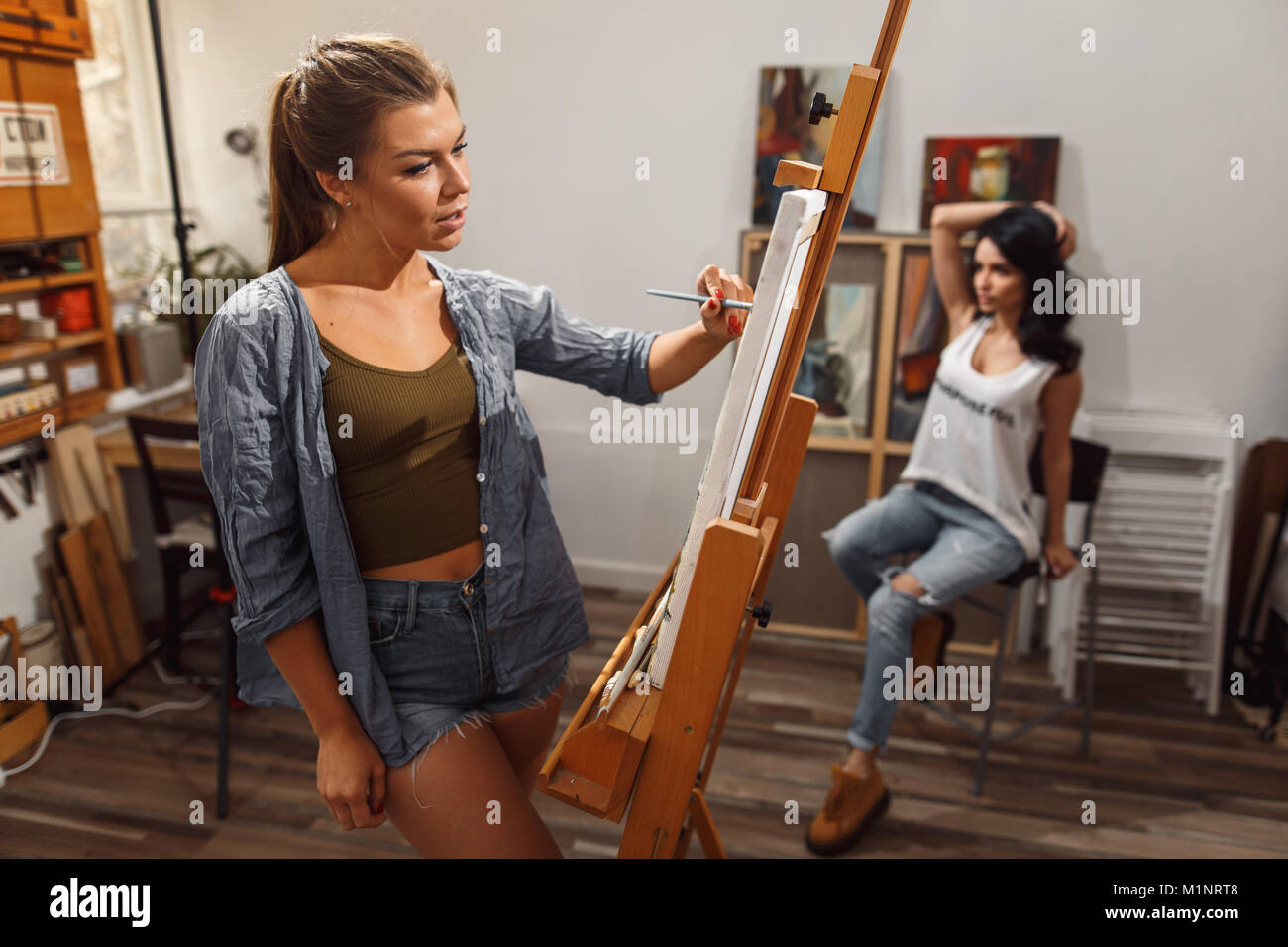 two girls in an artist studio. paints model Stock Photo - Alamy