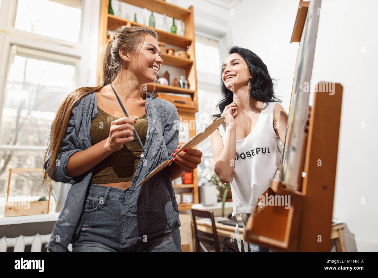 two girls in an artist studio. paints model Stock Photo - Alamy