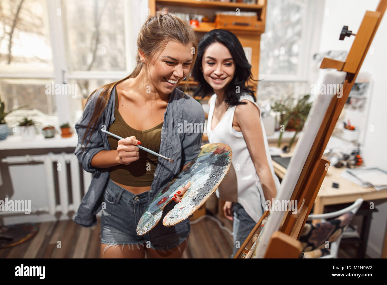 two girls in an artist studio. paints model Stock Photo - Alamy