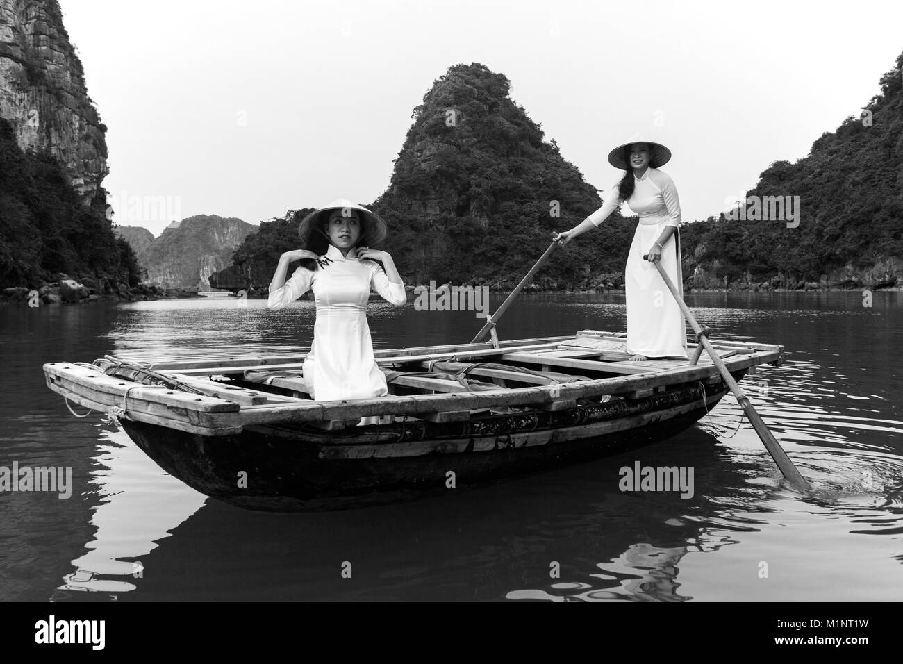Young women posing on a traditional rowboat in Halong Bay, Vietnam. The ...