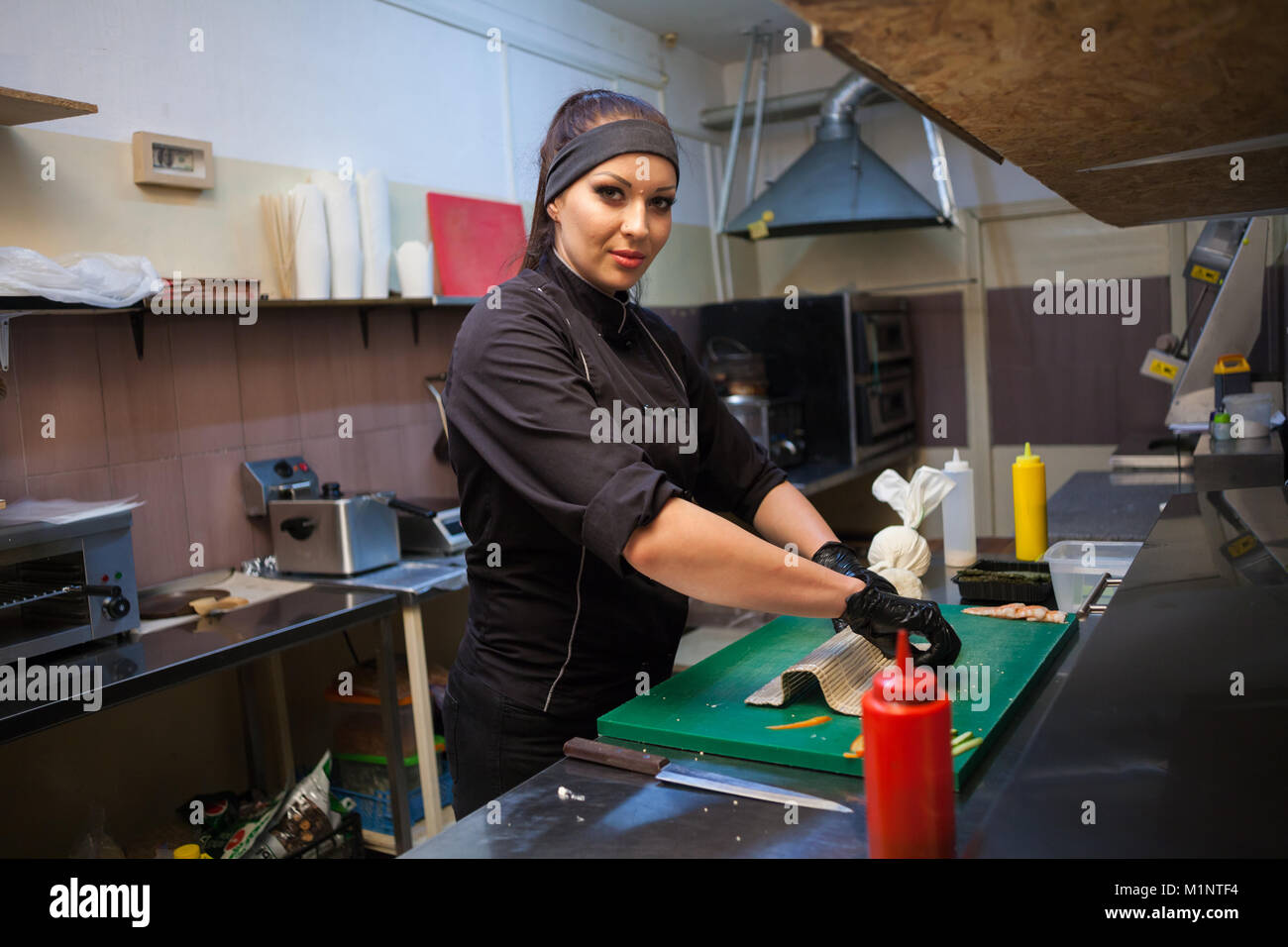girl sushi chef prepares food in the kitchen at restaurant Stock Photo ...