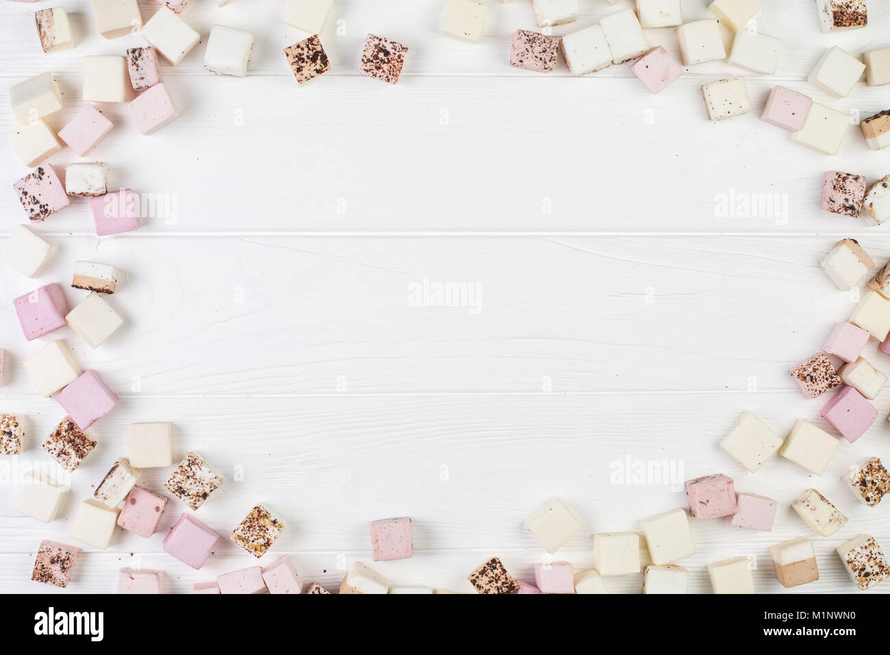 From above view of arranged of pink marshmallow cubes lying on white ...