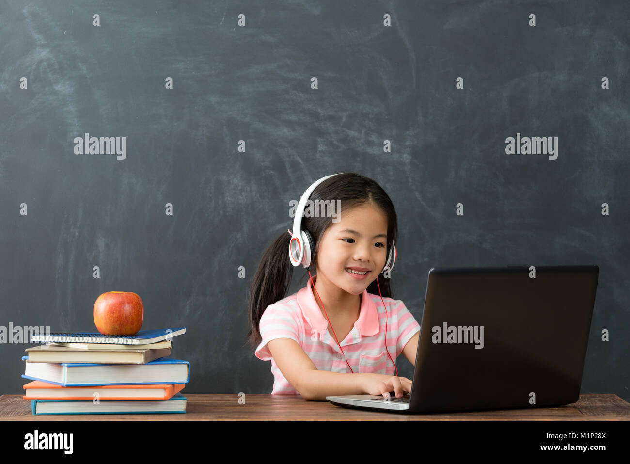 happy beautiful female student sitting in blackboard background and ...