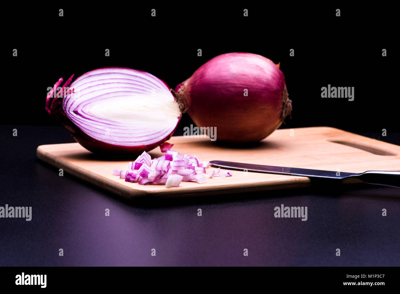 Red onion cut and all in black background Stock Photo - Alamy