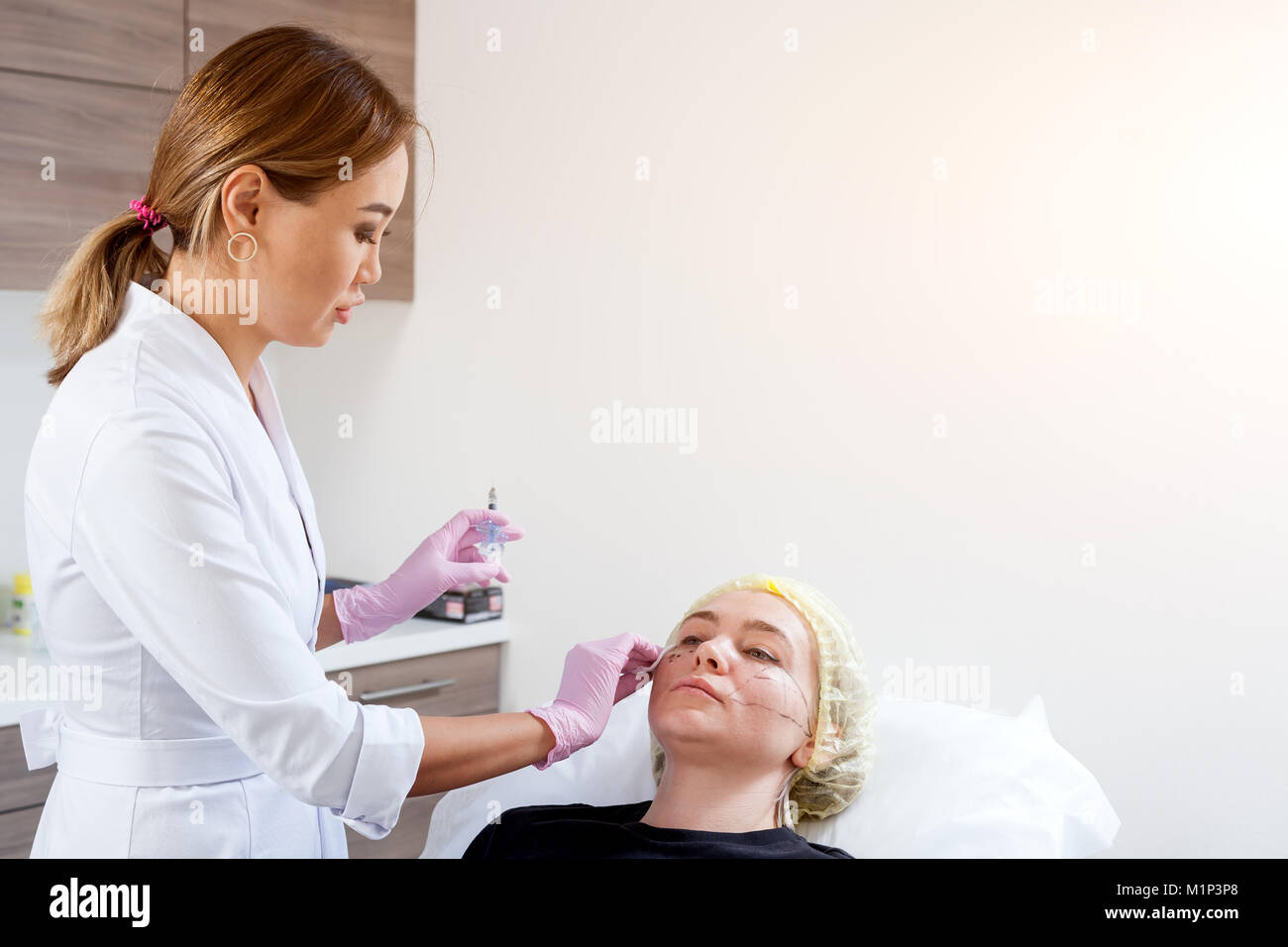 Close-up Young woman azian doctor cosmetician in white lab coat and ...