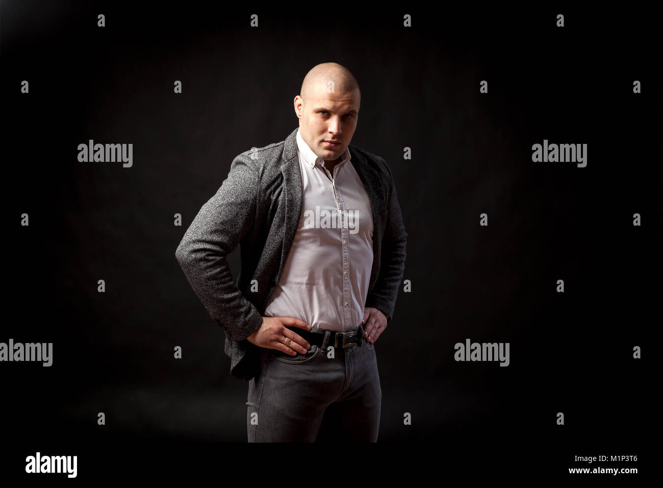 A young man manager in a white shirt, gray suit looks seriously and ...