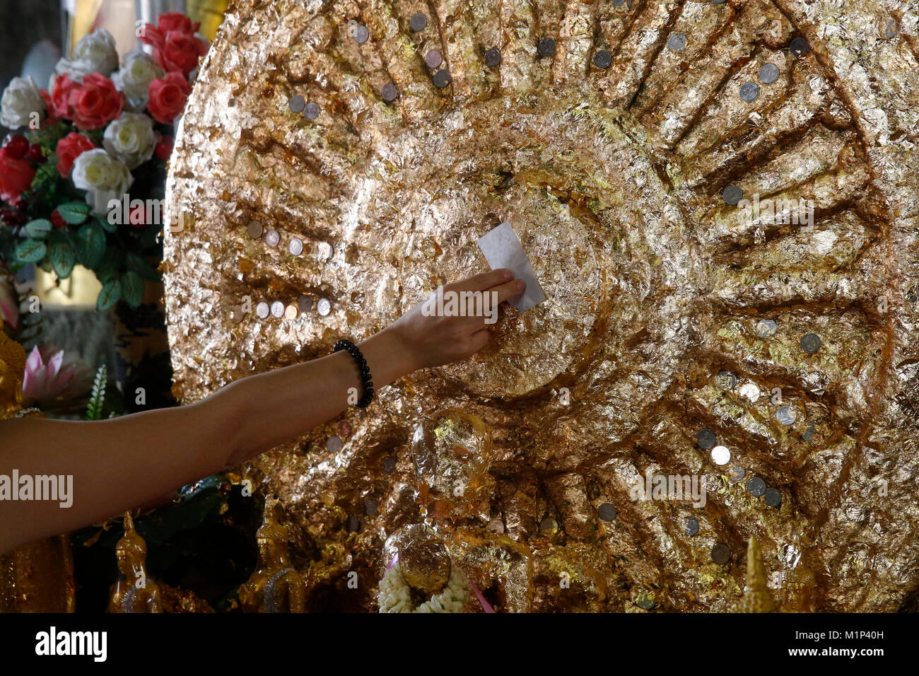 Faithful offering gold leaves in Wat Mahathat, Phetchaburi, Thailand ...