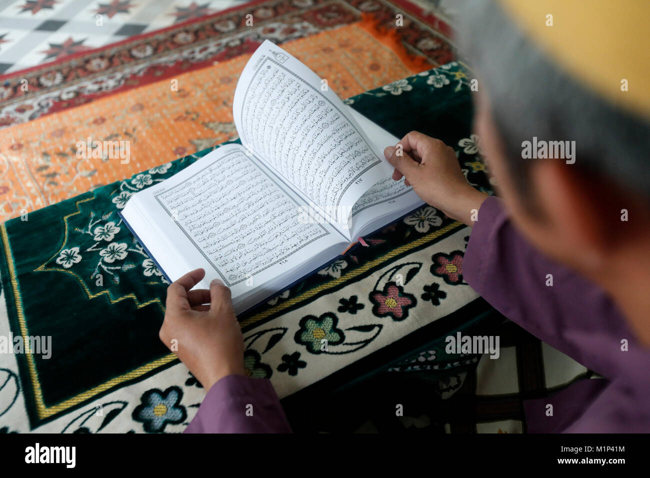 Muslim man reading an Arabic Holy Quran (Koran), Saigon Central Mosque ...