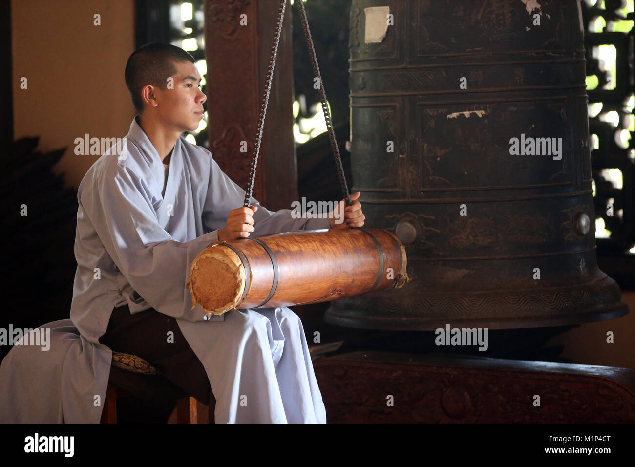 Linh An Buddhist pagoda, young monk ringing bell in monastery, Dalat ...