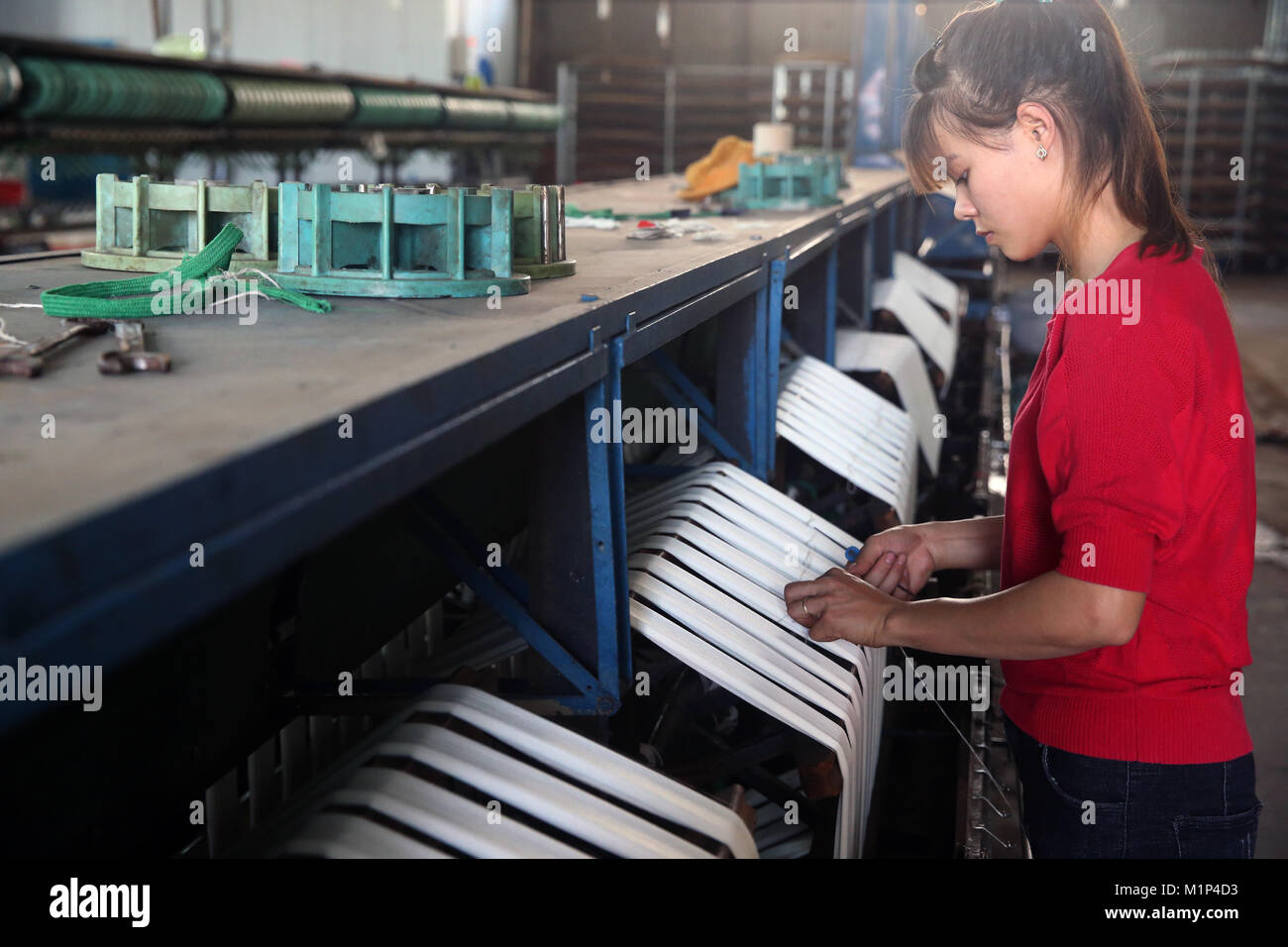 Woman working on silk spinning machine in traditional silk factory ...