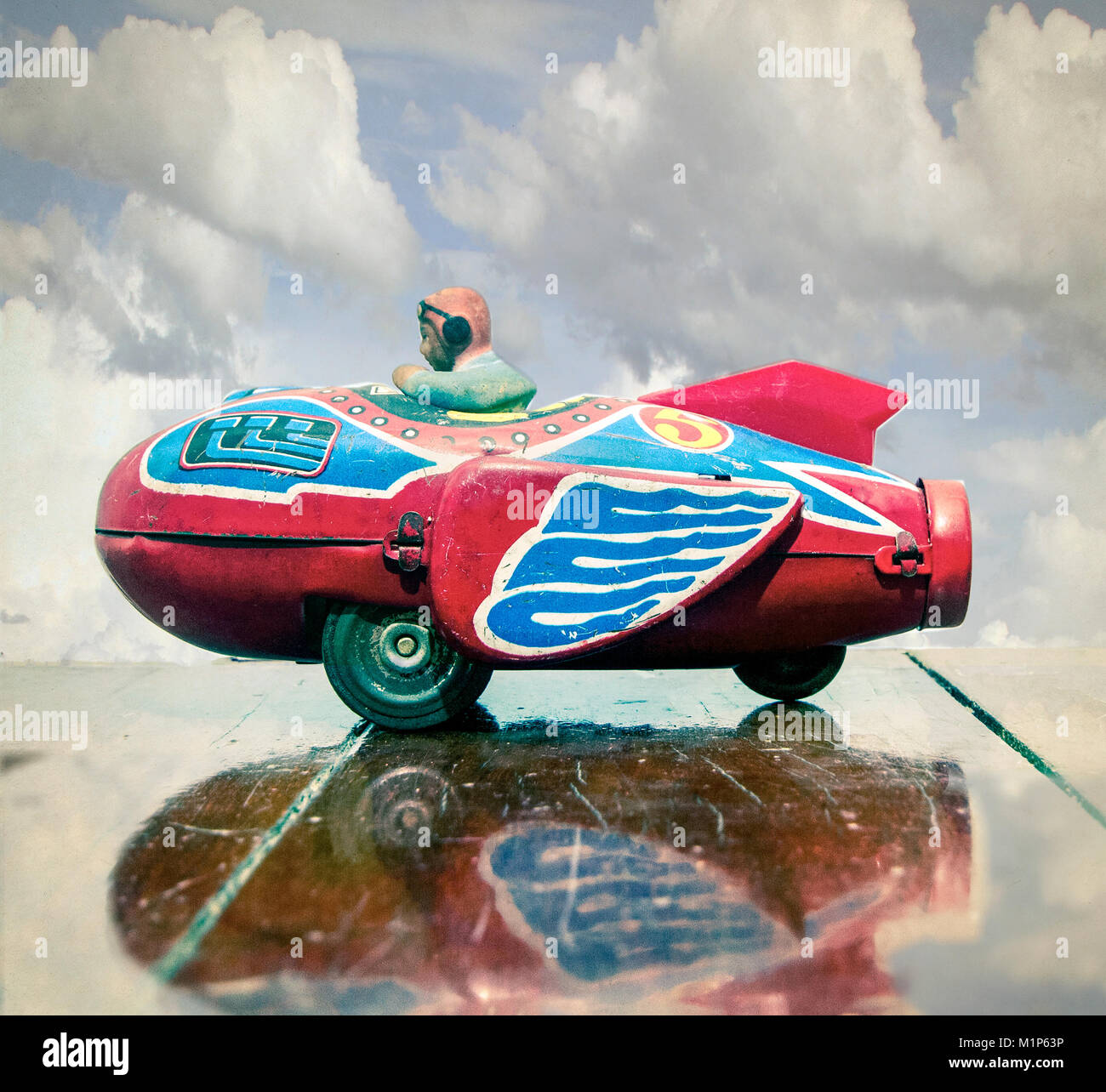 retro rocket tin toy close up on a wooden floor sky and clouds ...