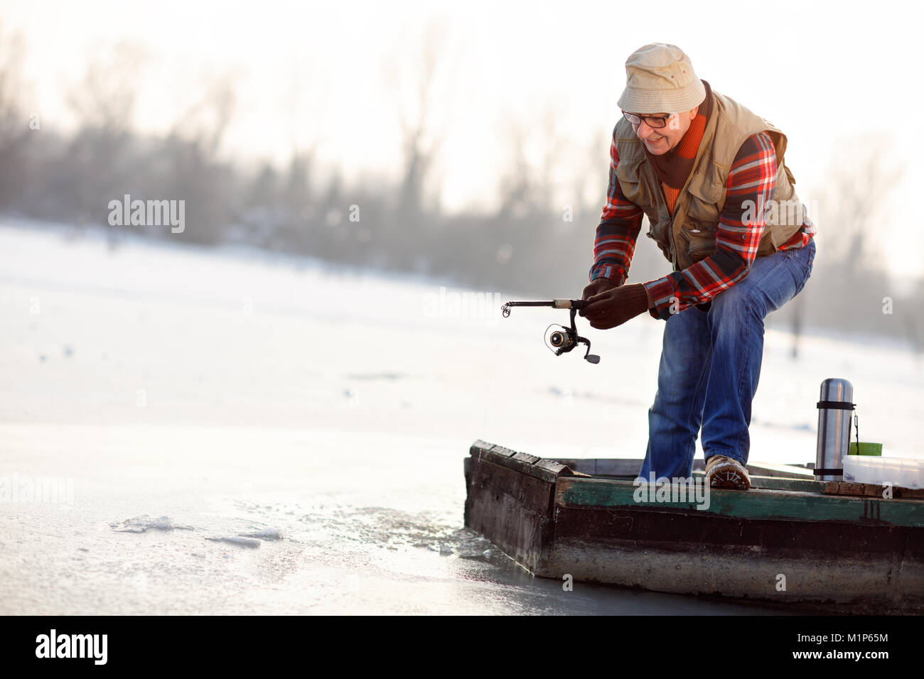 Fisherman pulling up catch in boat Stock Photo - Alamy