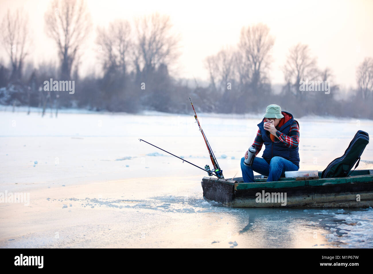 Old man fishing fish on winter and drinking tea in boat Stock Photo - Alamy