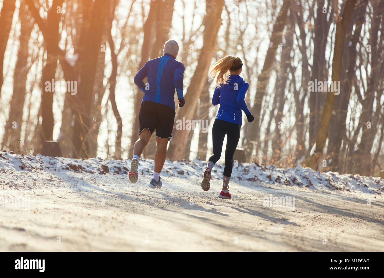 Young runners couple running through forest, back view Stock Photo - Alamy