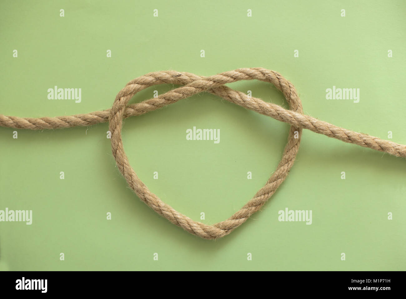 Rope in heart shape on a green background Stock Photo - Alamy