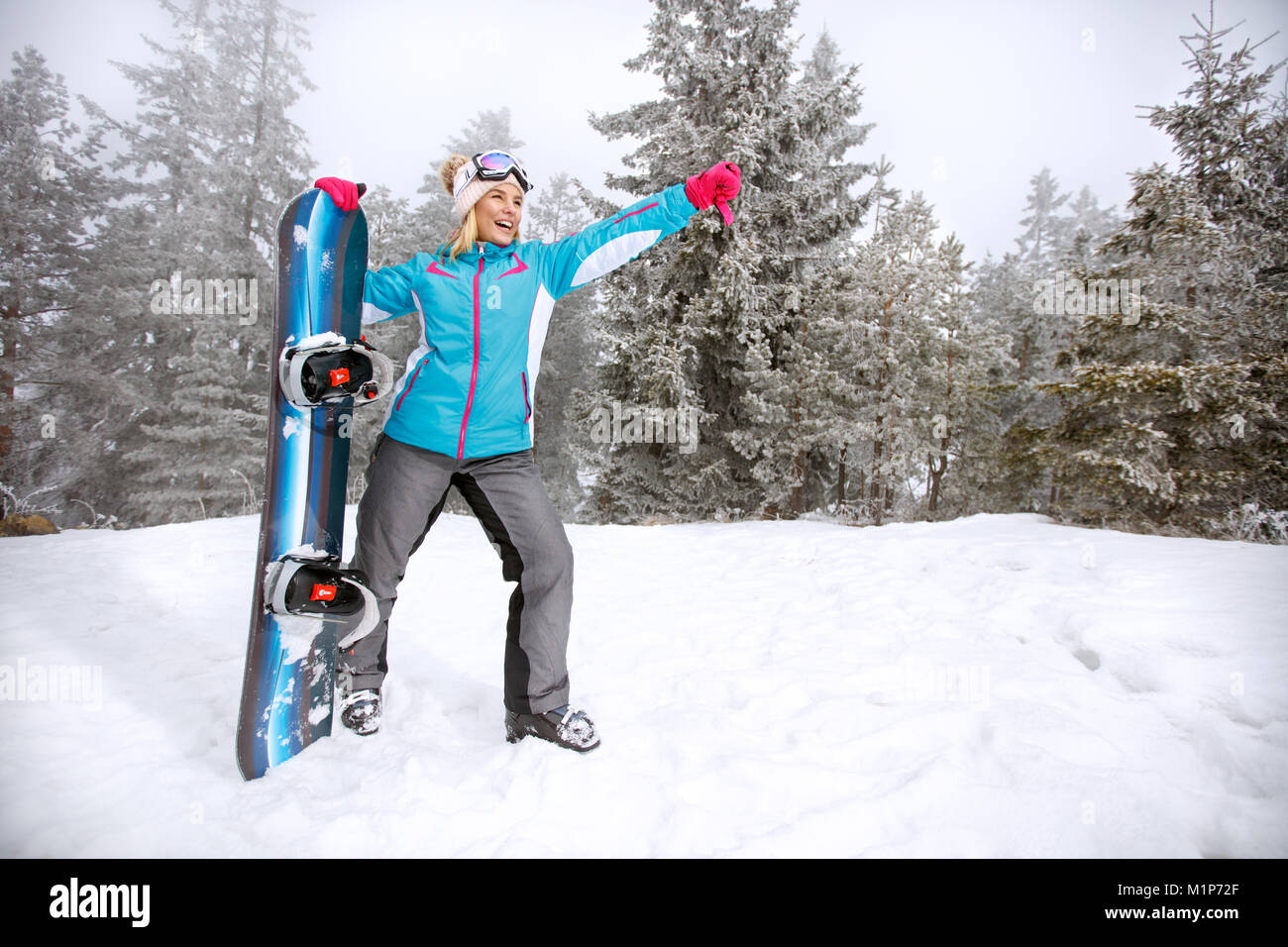 Female snowboarder in mountain in winning pose Stock Photo - Alamy