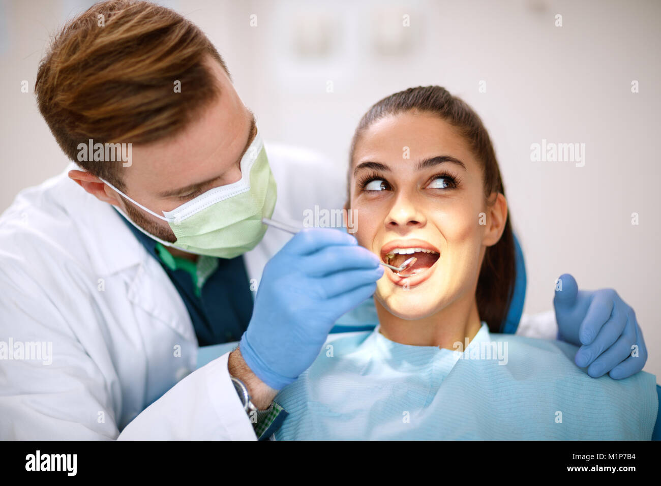 Male dentist checking up girl’s teeth with mirror Stock Photo - Alamy