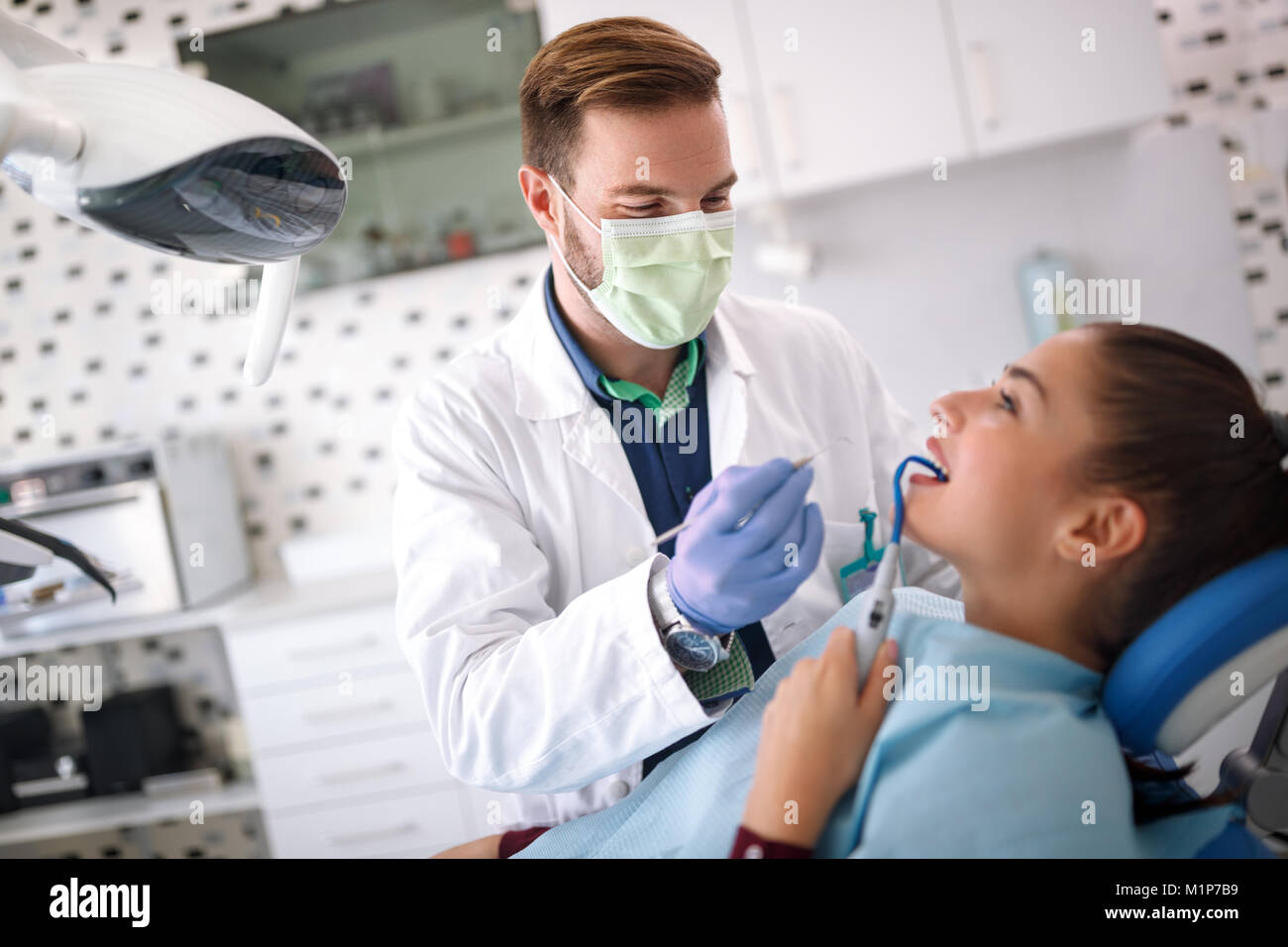 Male dentist repairing girl’s tooth on clinic Stock Photo - Alamy