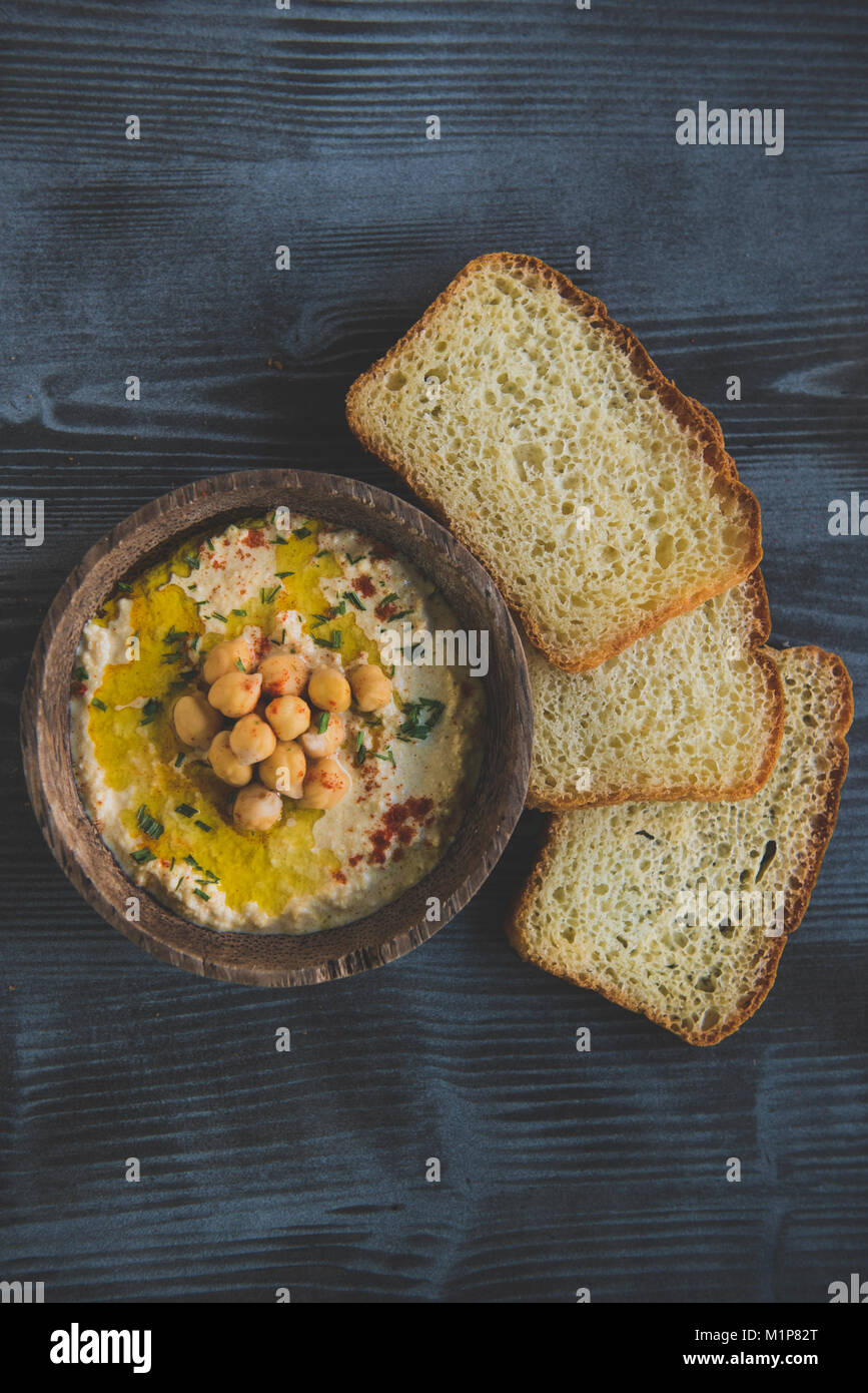 HUmus in the wooden bowl with bread slices,selective focus Stock Photo ...
