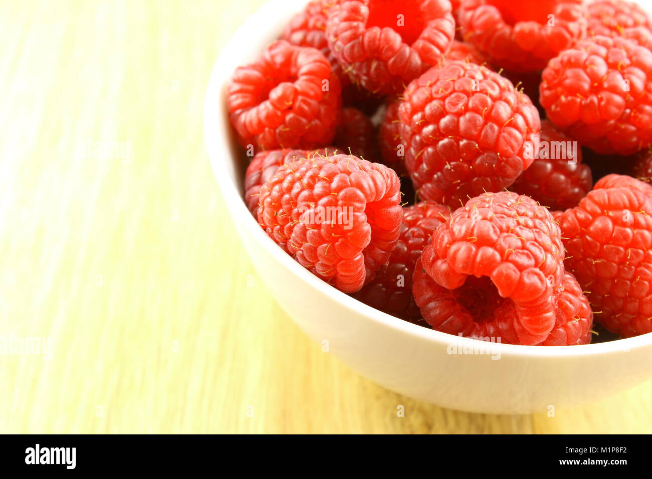 fresh red raspberry fruits in a small white bowl Stock Photo - Alamy