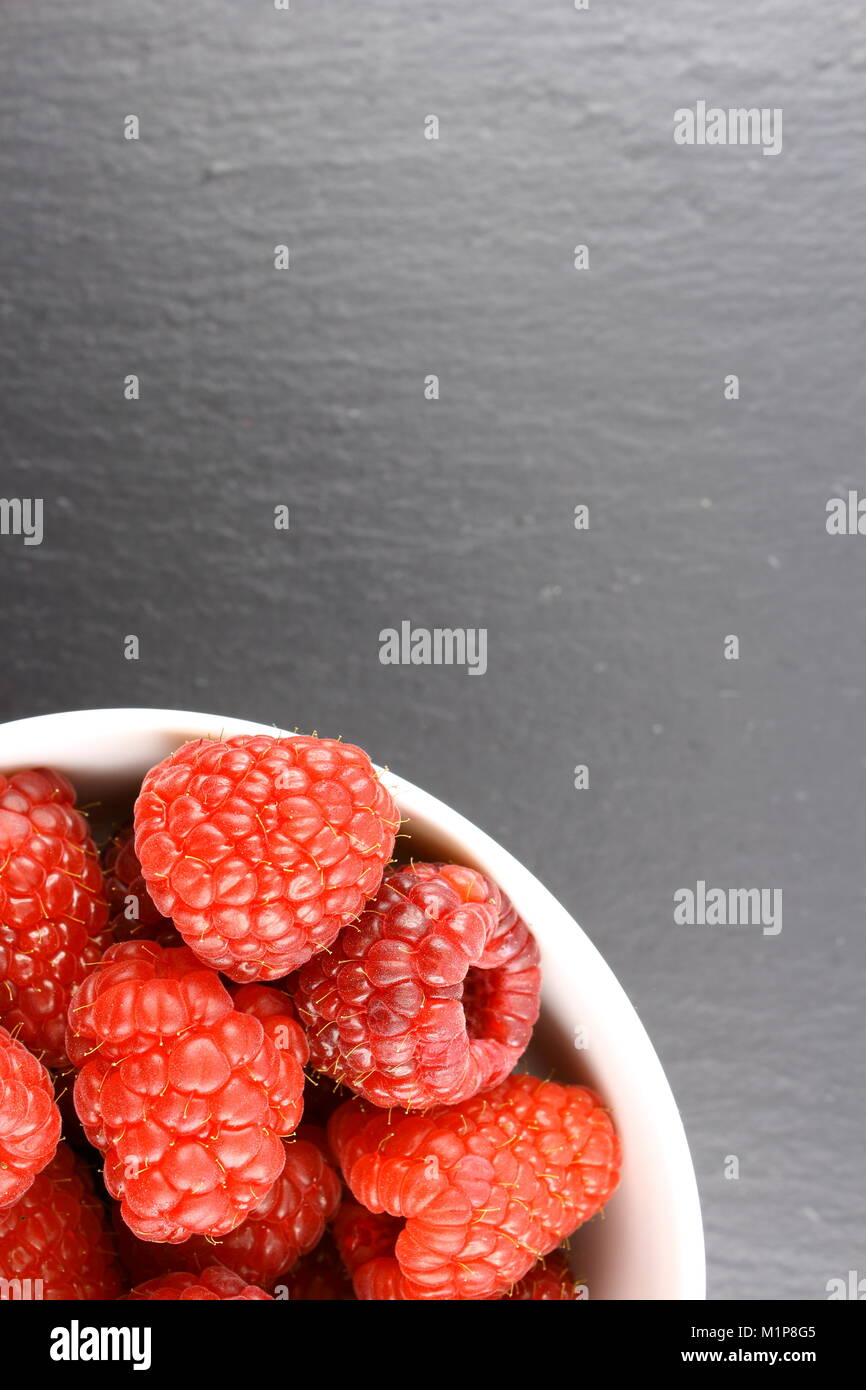 fresh red raspberry fruits in a small white bowl Stock Photo - Alamy