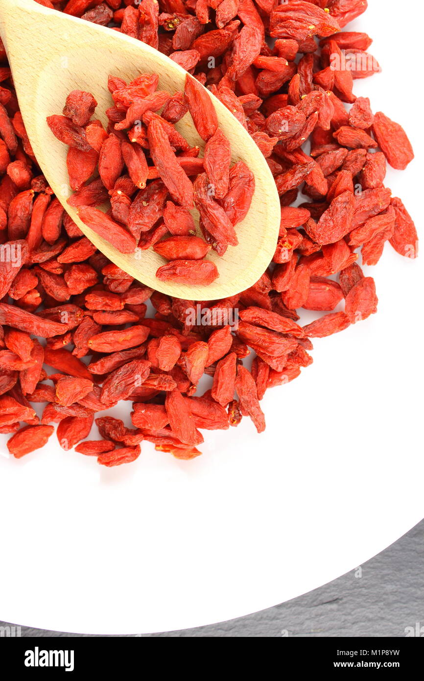 composition of dried goji berries on a wooden spoon Stock Photo - Alamy