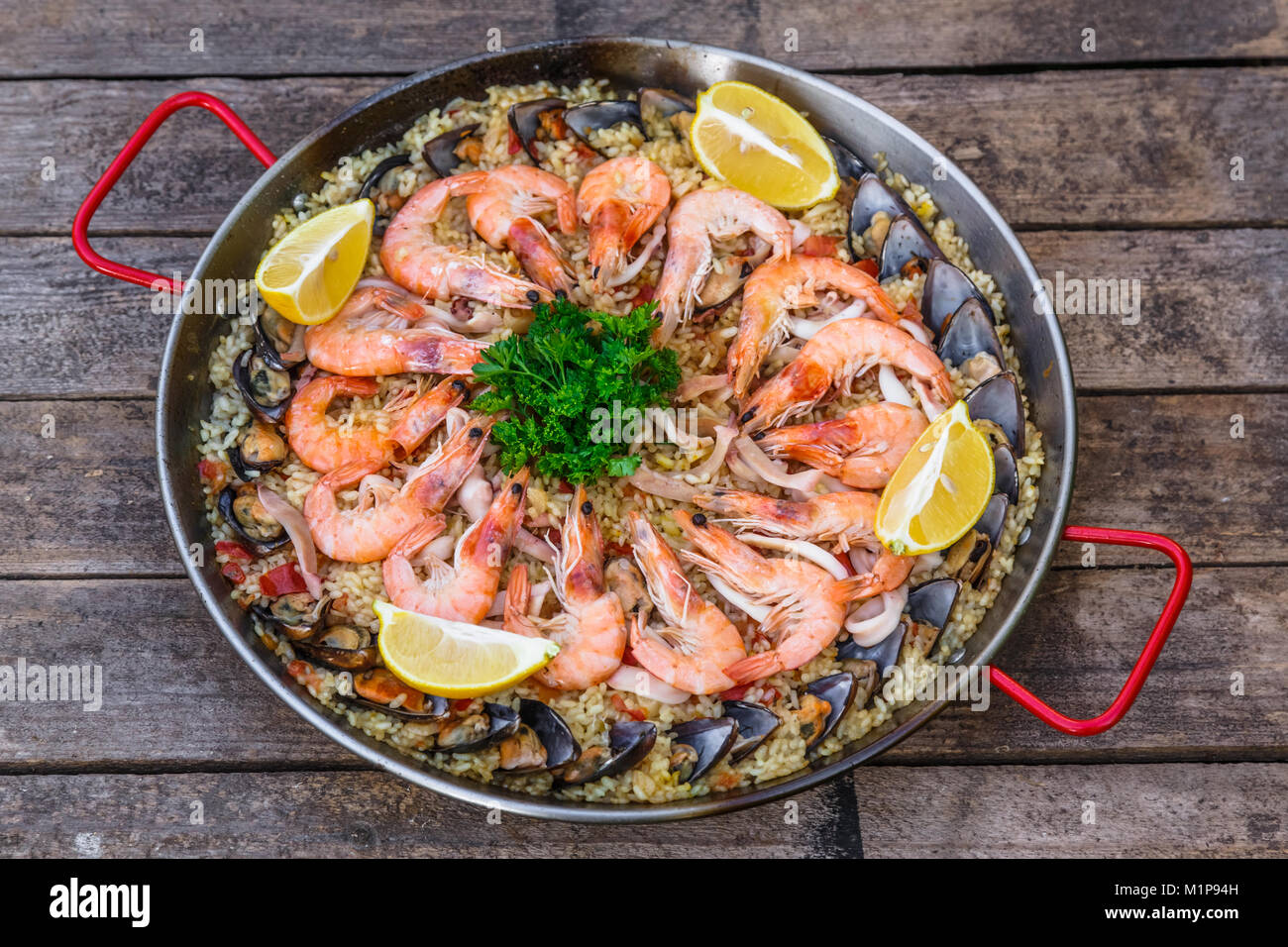 Traditional seafood paella in the fry pan on a wooden old table, top ...