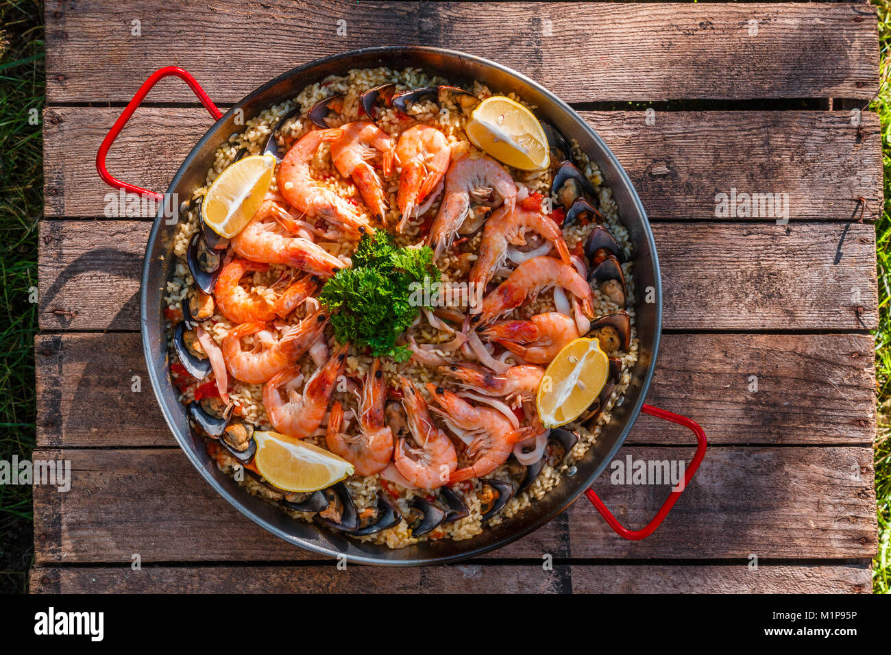 Traditional seafood paella in the fry pan on a wooden old table, top ...