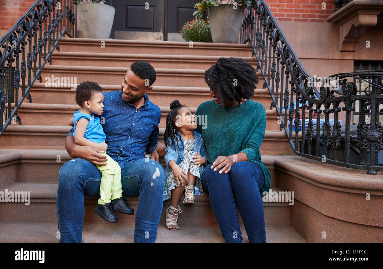 Young family with kids sitting on front stoops Stock Photo - Alamy