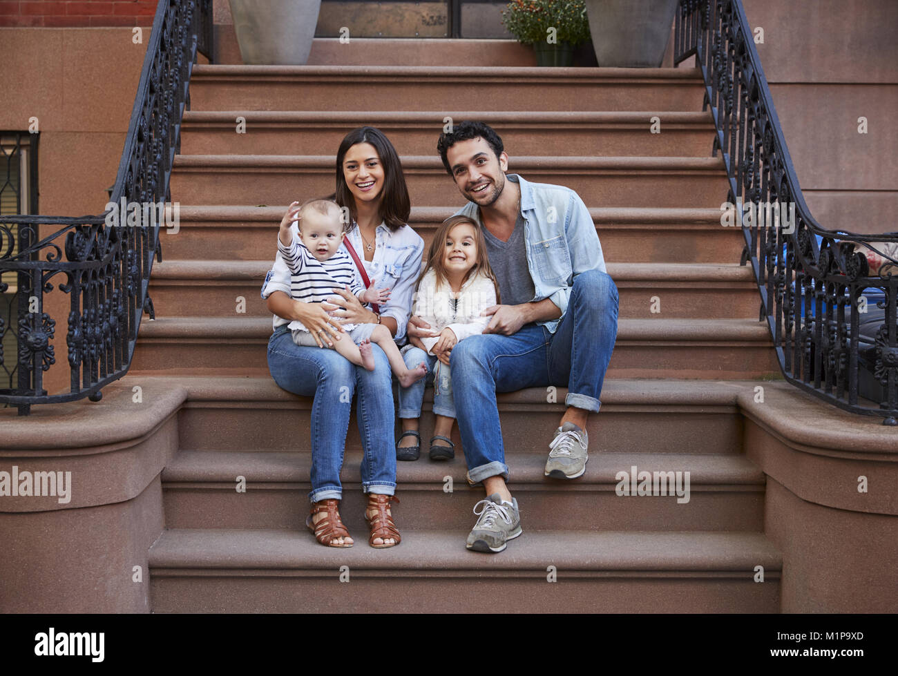 Young family with kids sitting on front stoops Stock Photo - Alamy