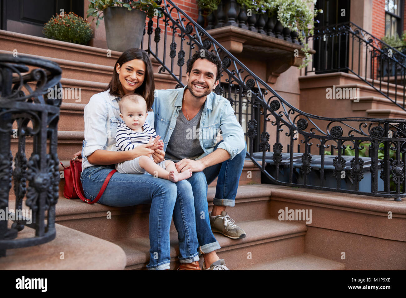 Young family with kids sitting on front stoops Stock Photo - Alamy
