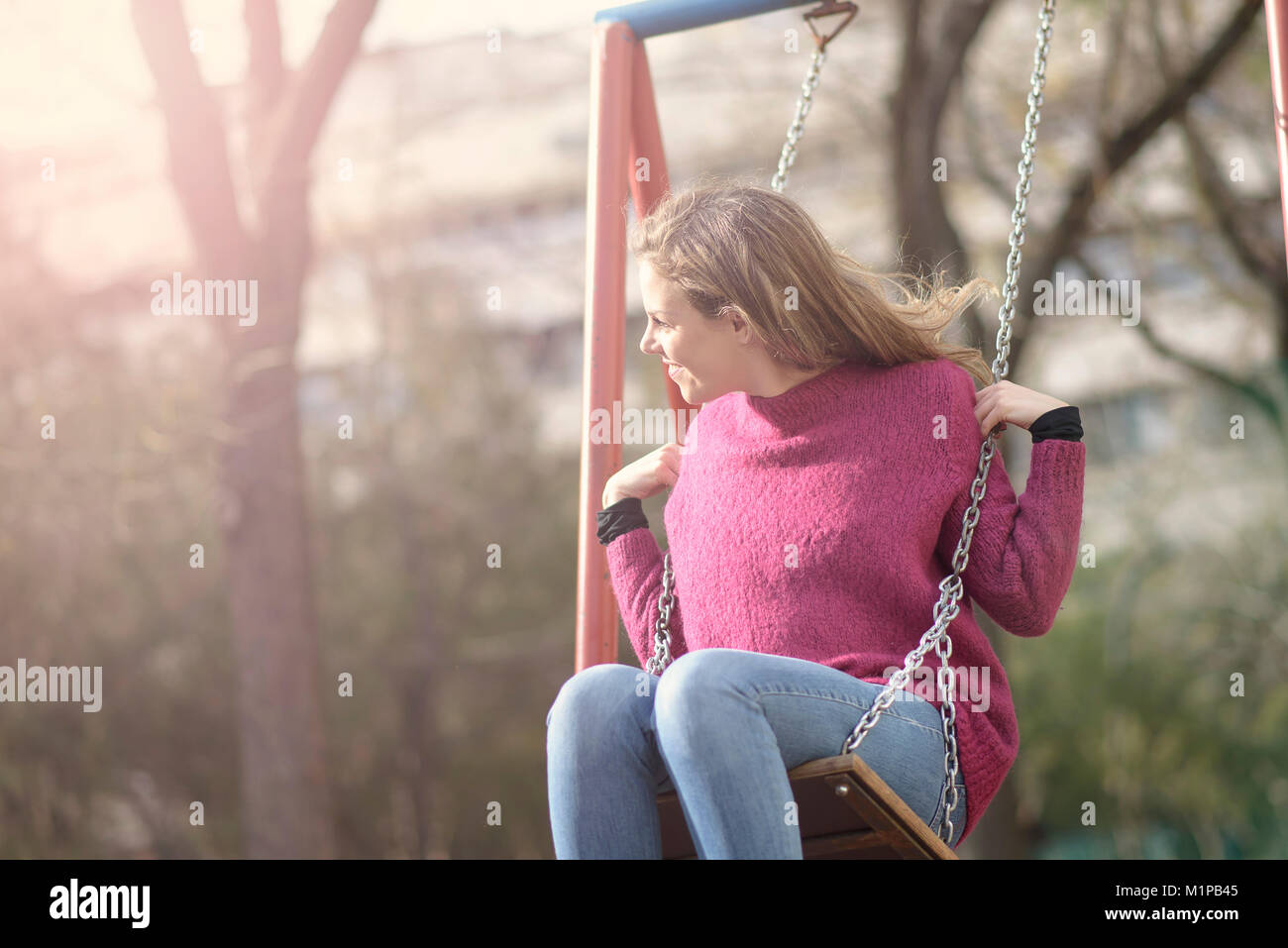 Reliving childhood, swinging in a park Stock Photo - Alamy