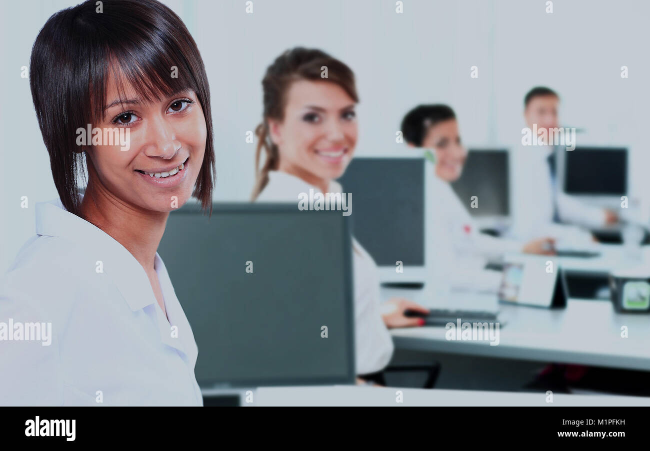 Business woman with a computer at the office with a group behind Stock ...