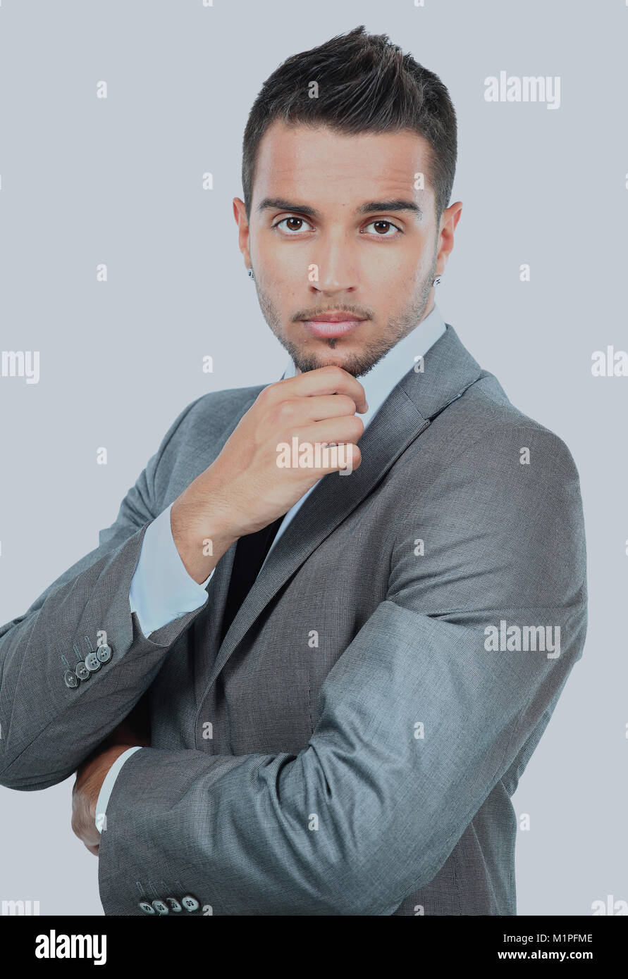Portrait of a stylish young man standing with hands folded over white ...