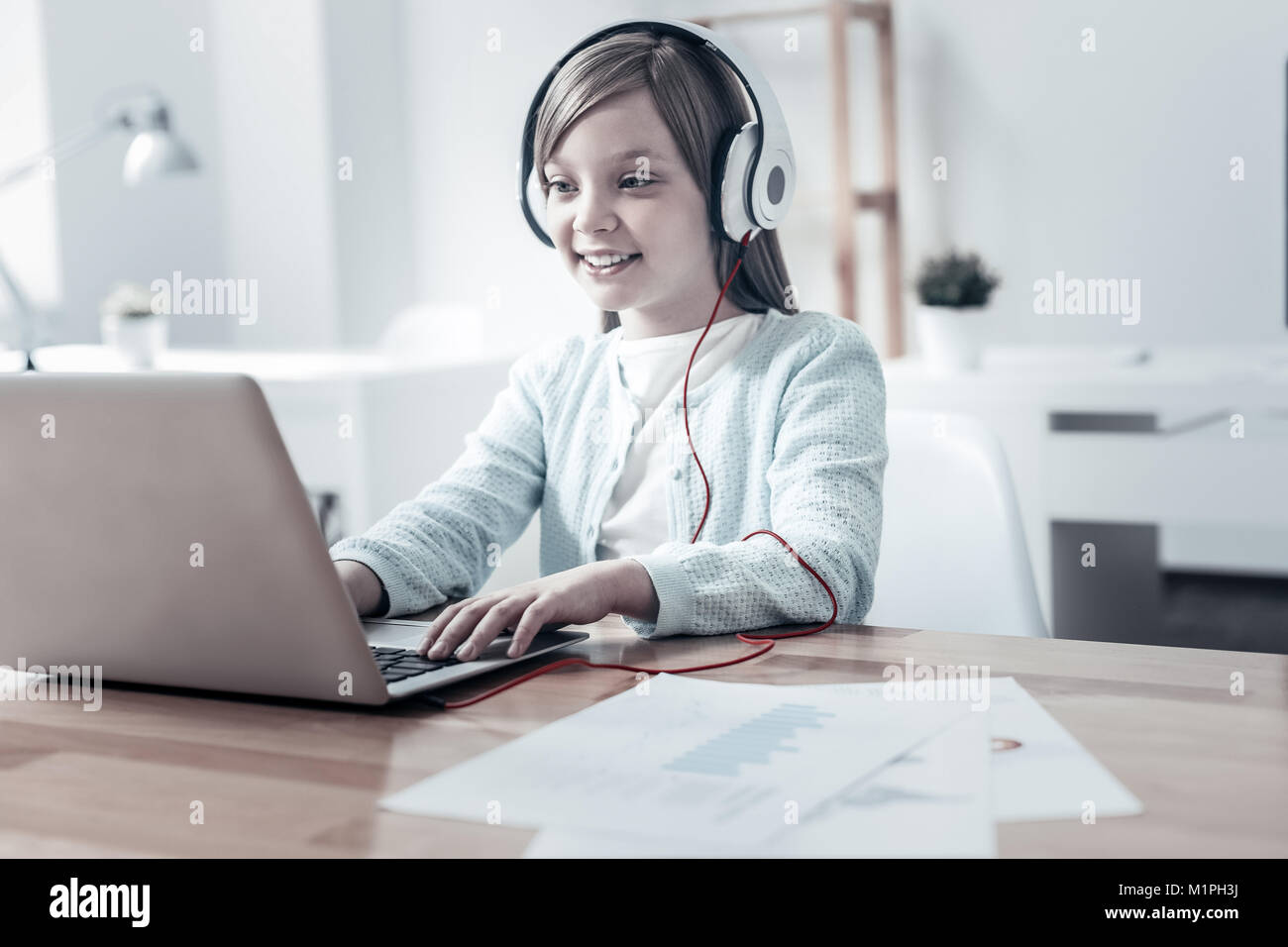 Adorable young lady listening to music on computer Stock Photo - Alamy