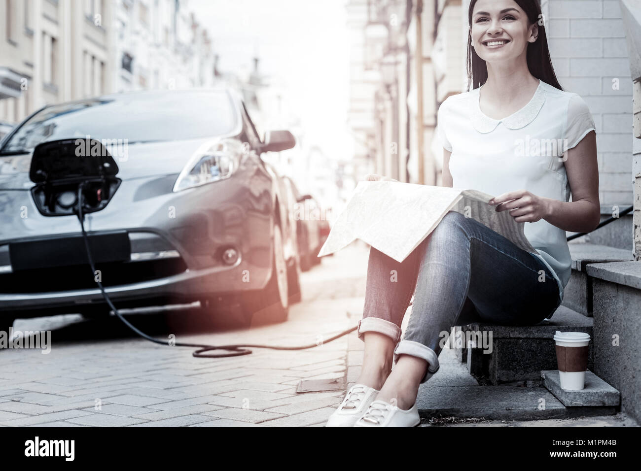 Joyful lady waiting for her charging in city street Stock Photo - Alamy