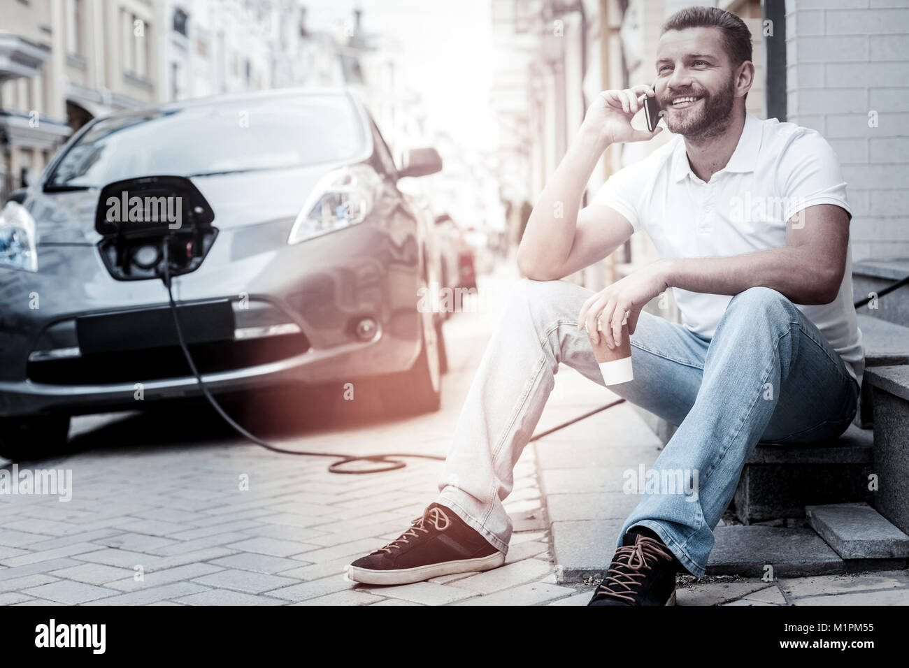 Smiling electric car owner enjoying car conversation Stock Photo - Alamy