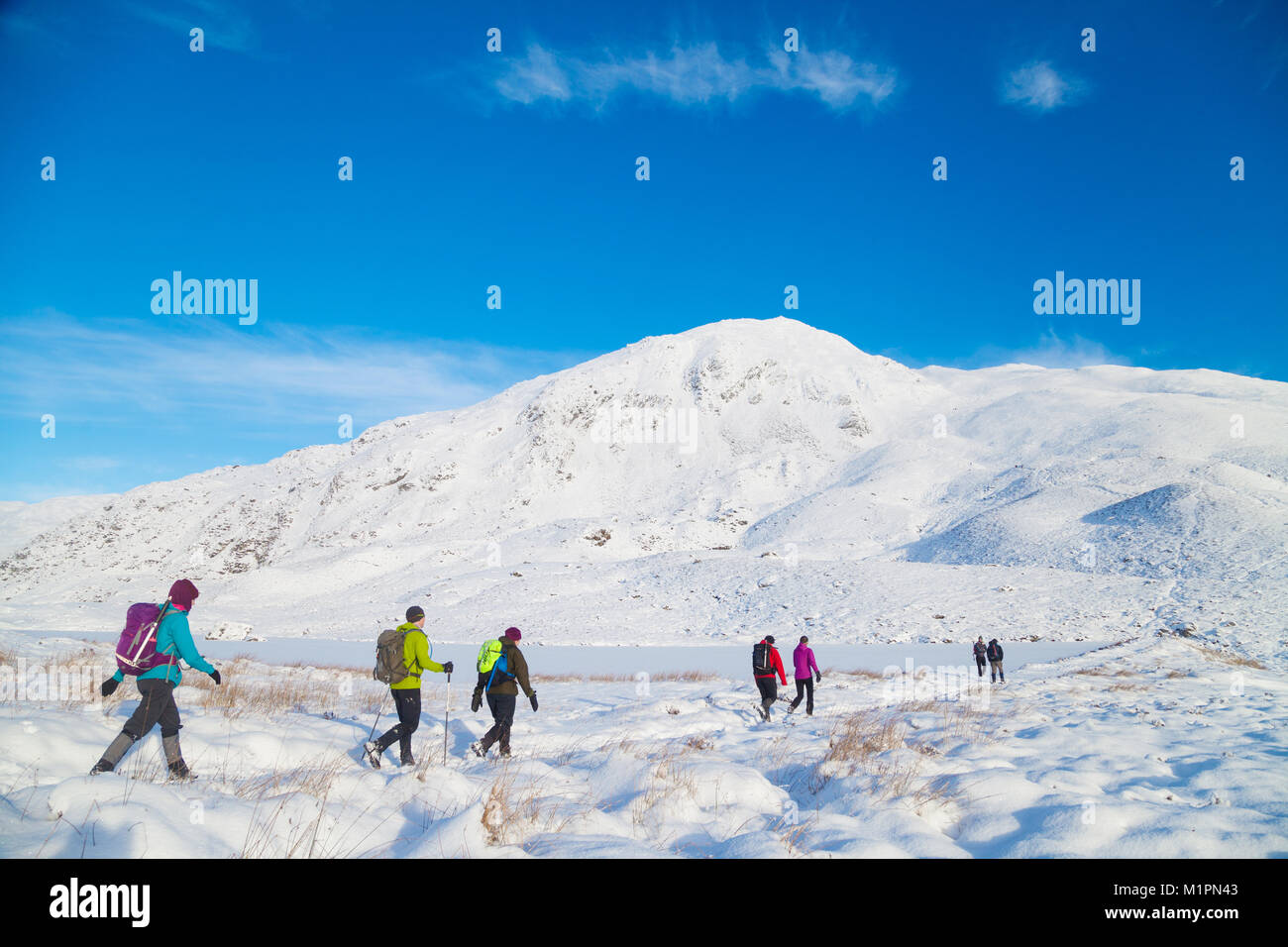 A group of walkers walking past Loch a' Choire on the way to the ...