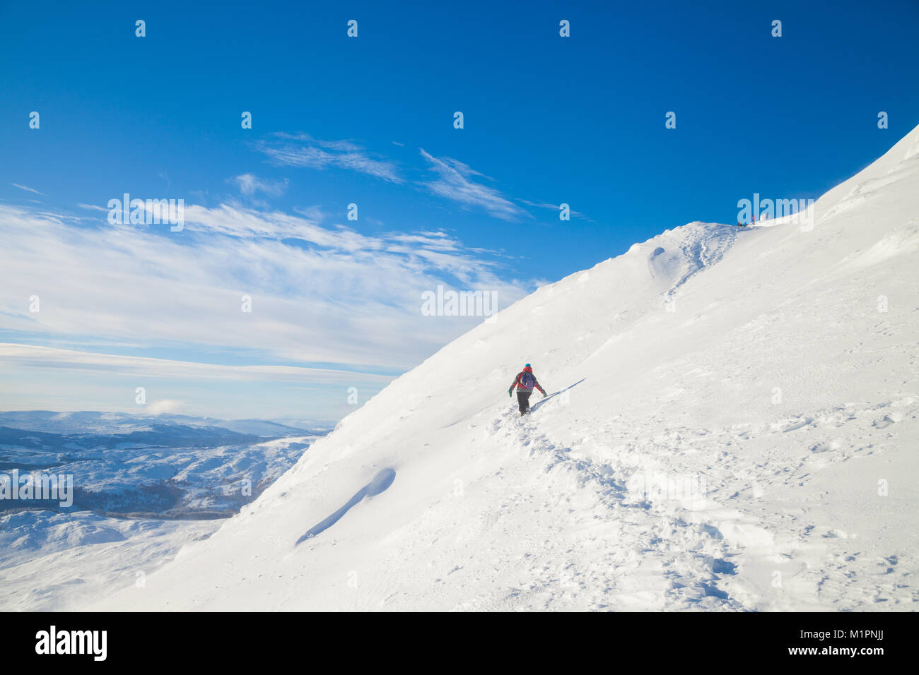 A walker approaching the summit of Ben Vrackie through deep snow Stock ...