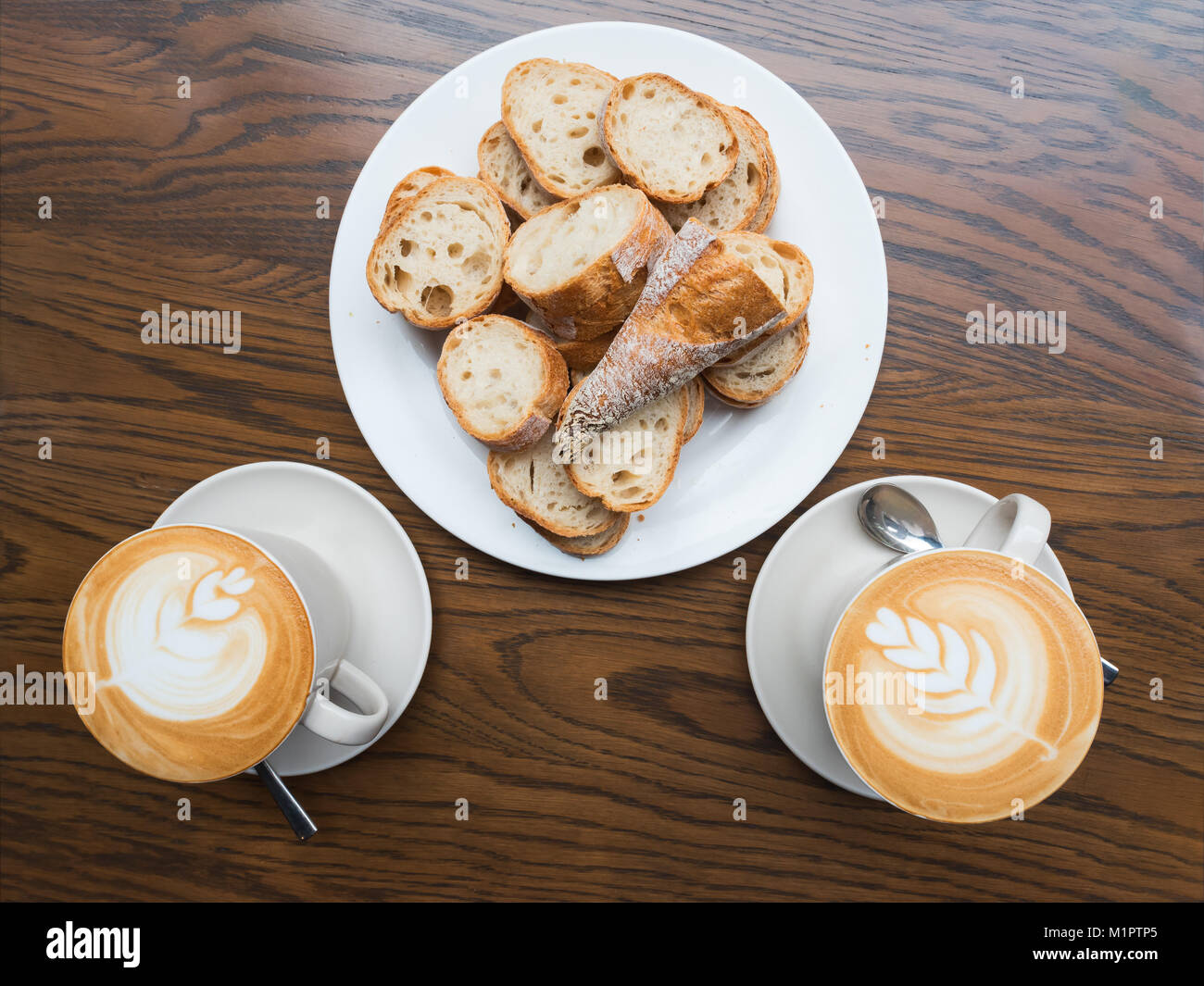 Two cappuccino cups and sliced bread Stock Photo - Alamy