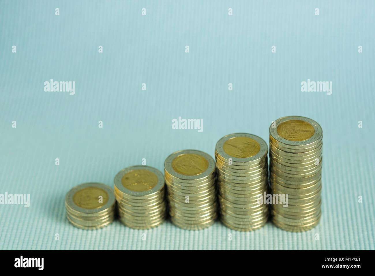 Increasing columns of coins, step of coin stacks with copy space for ...