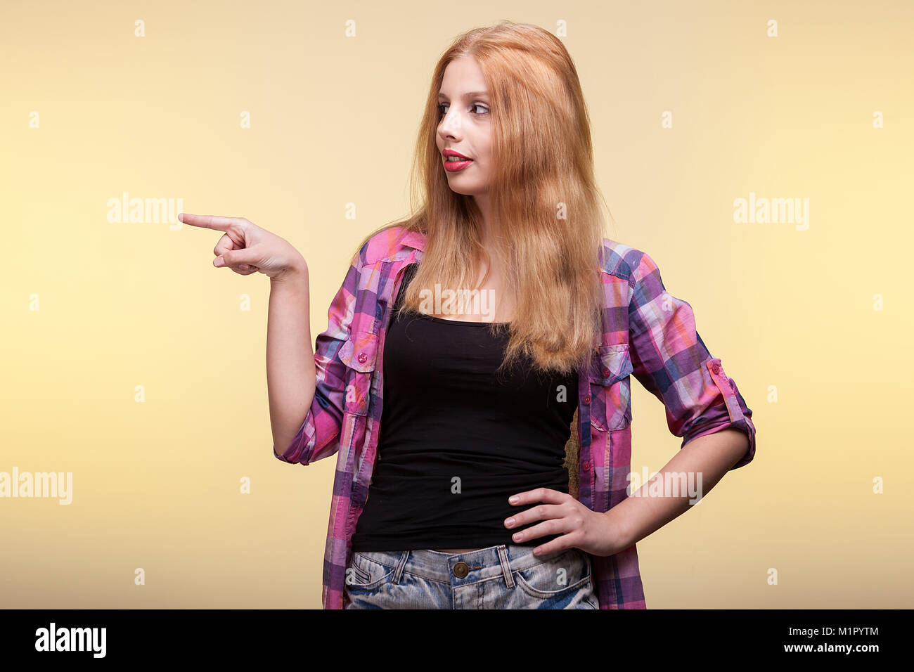 Young woman pointing to her right Stock Photo - Alamy
