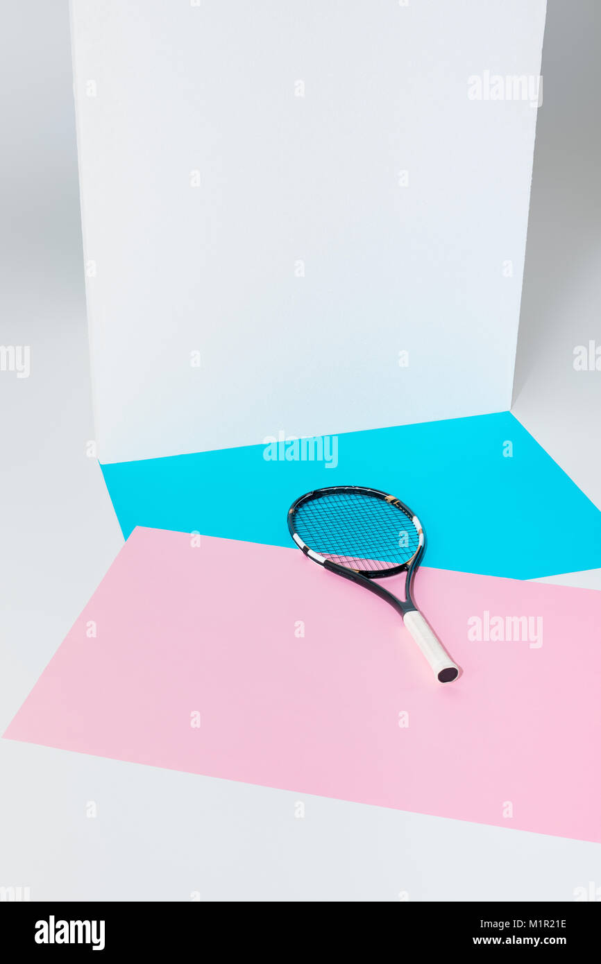 tennis racket lying on blue and pink papers at white wall Stock Photo ...