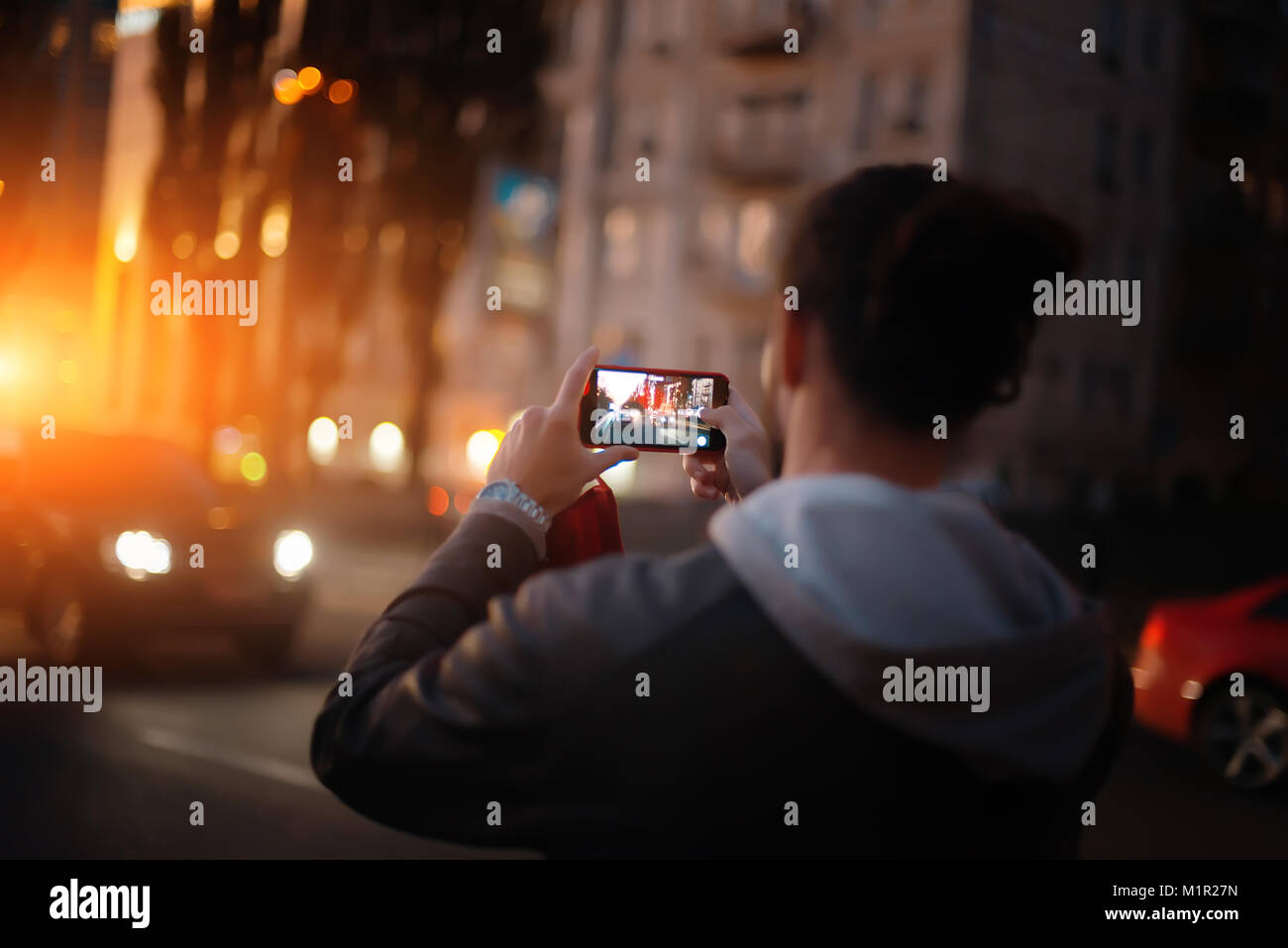 Urban photographer with mobila phone make photo on street. The guy ...