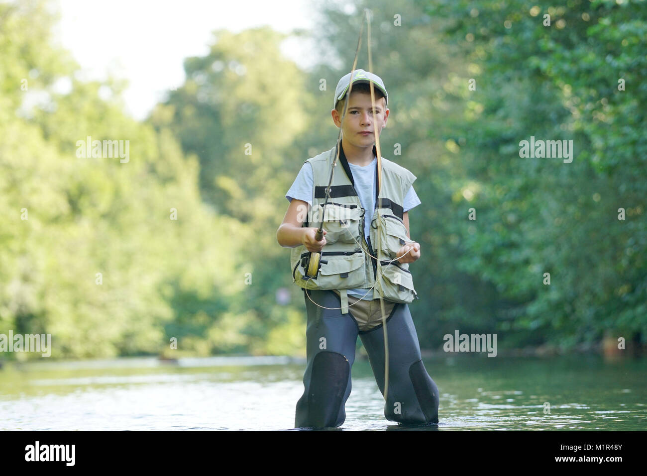 Young boy fly-fishing in river Stock Photo - Alamy