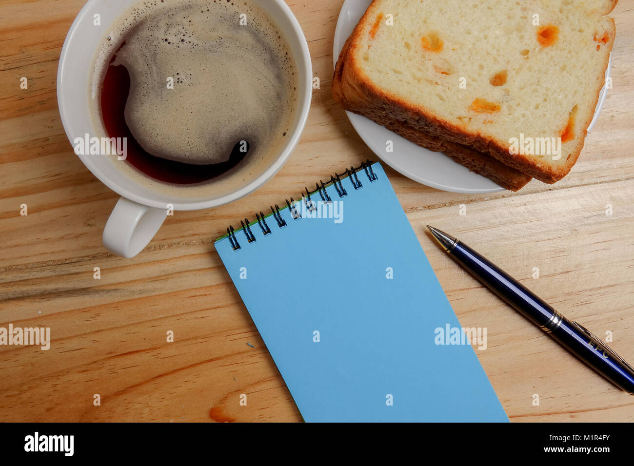Blank notepad and coffee cup on office wooden table Stock Photo - Alamy