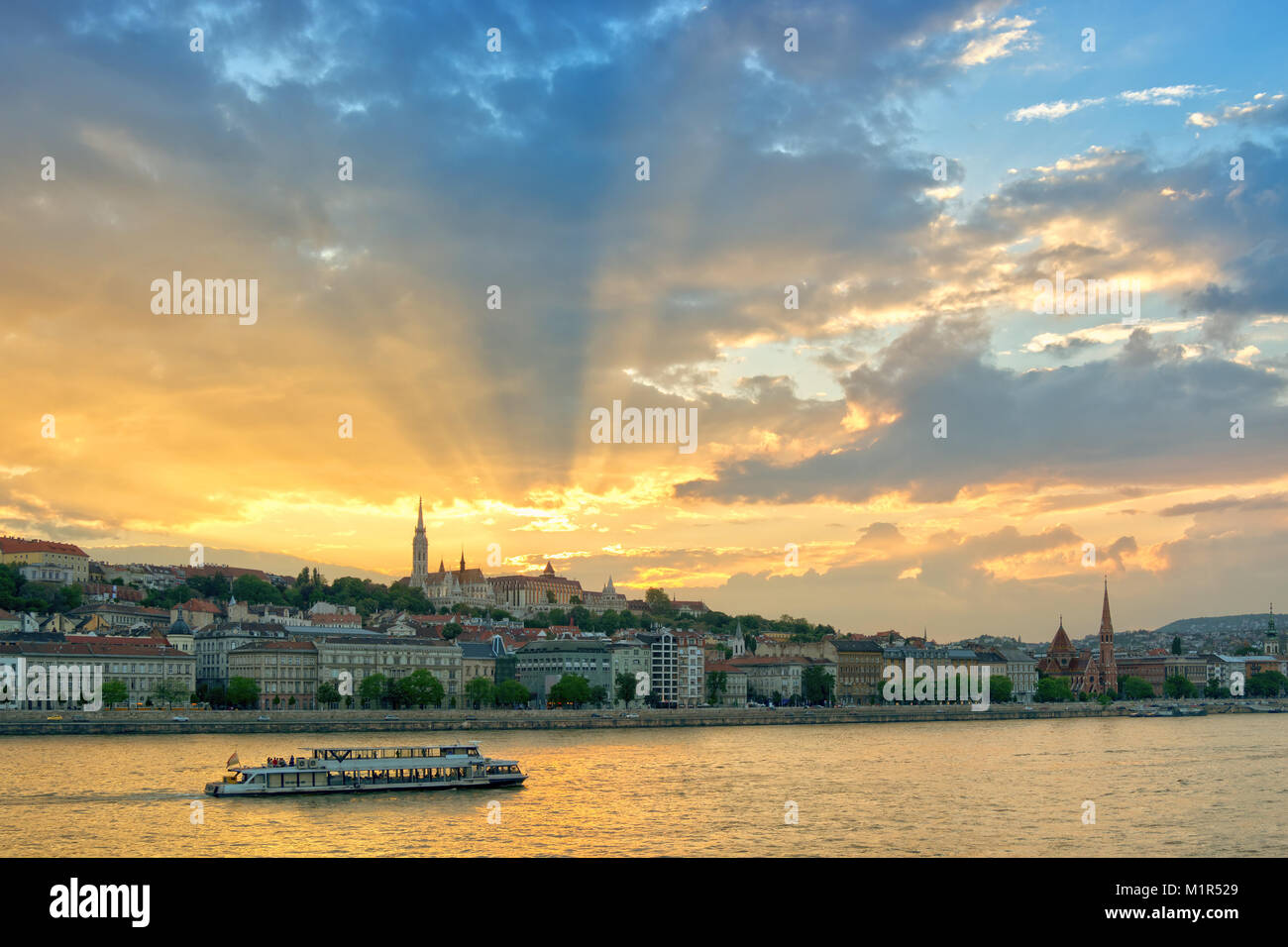 Scenic sunset, sun rays through clouds. Danube river and Budapest city ...